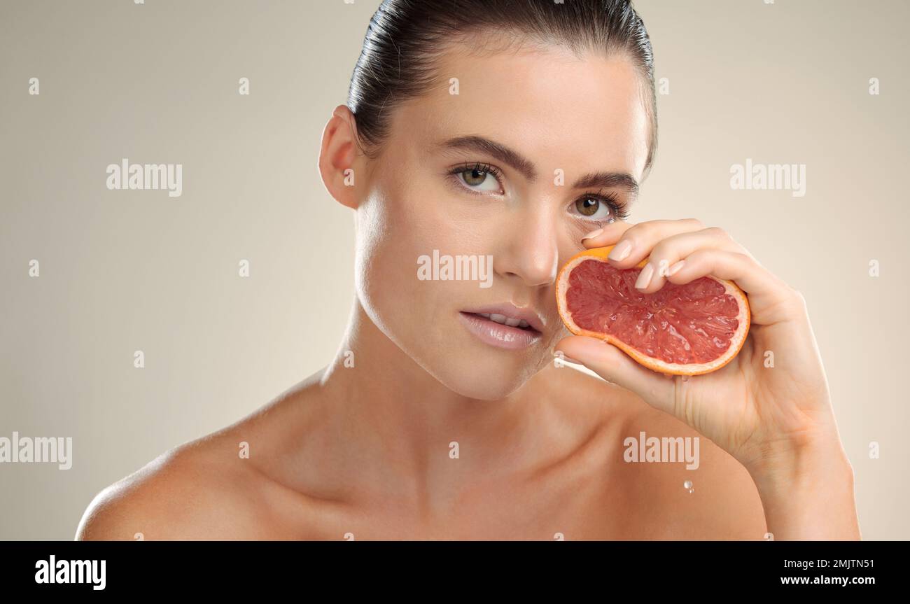 Beauty, grapefruit squeeze and skincare woman portrait in studio with ...