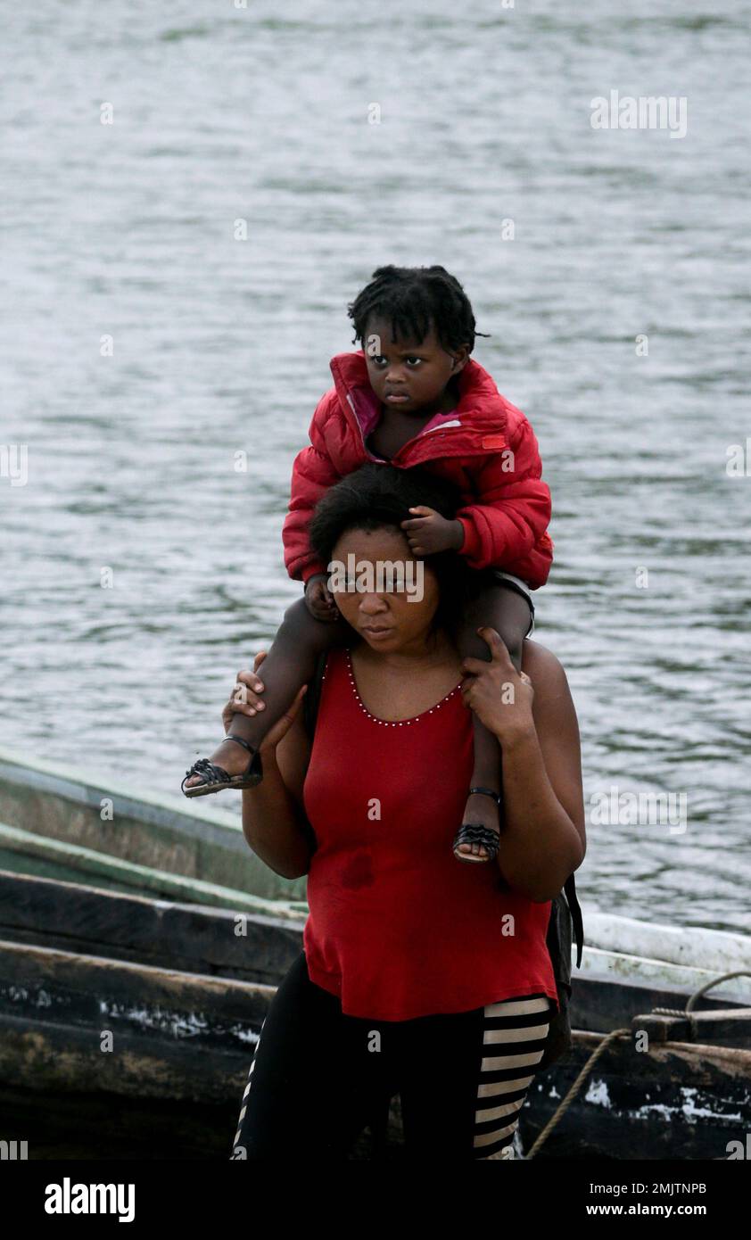 In this May 25, 2019 photo, a migrant woman carries her child on her ...