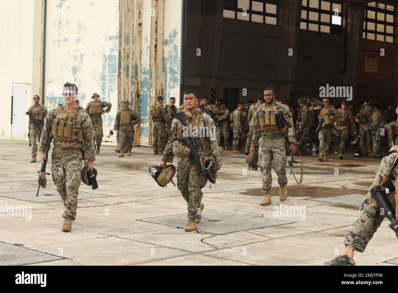 U.S. Marines with 3d Marine Division depart an aircraft hangar after ...