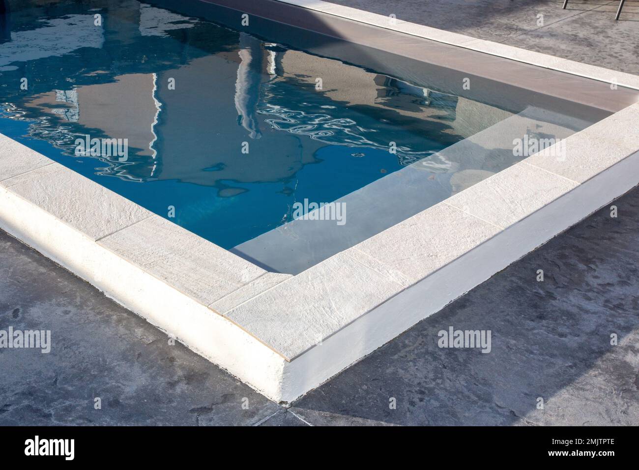 home blue swimming pool with stone coping with a waxed concrete terrace ...