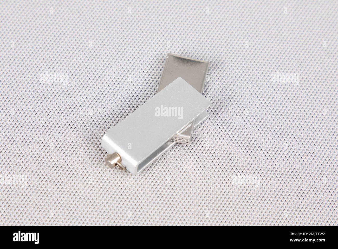 metal silver USB flash drive ready to connected on white desk grey ...