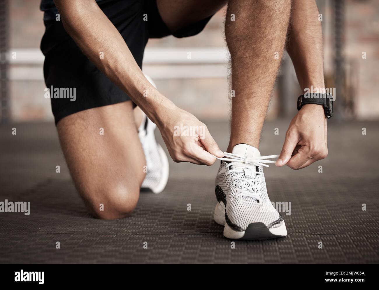 Fitness, man and shoe lace tie getting ready for running exercise, workout or training at gym ...