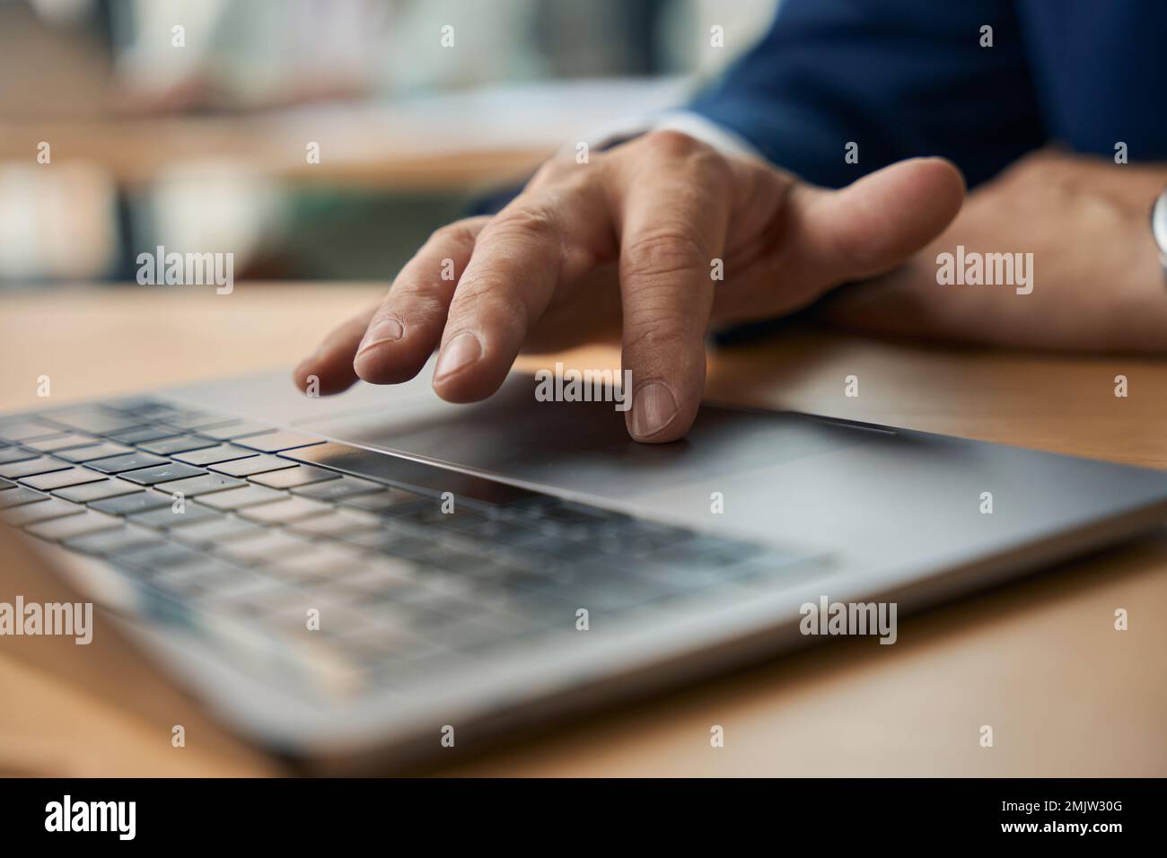 Male office worker using touchpad while working on laptop Stock Photo ...