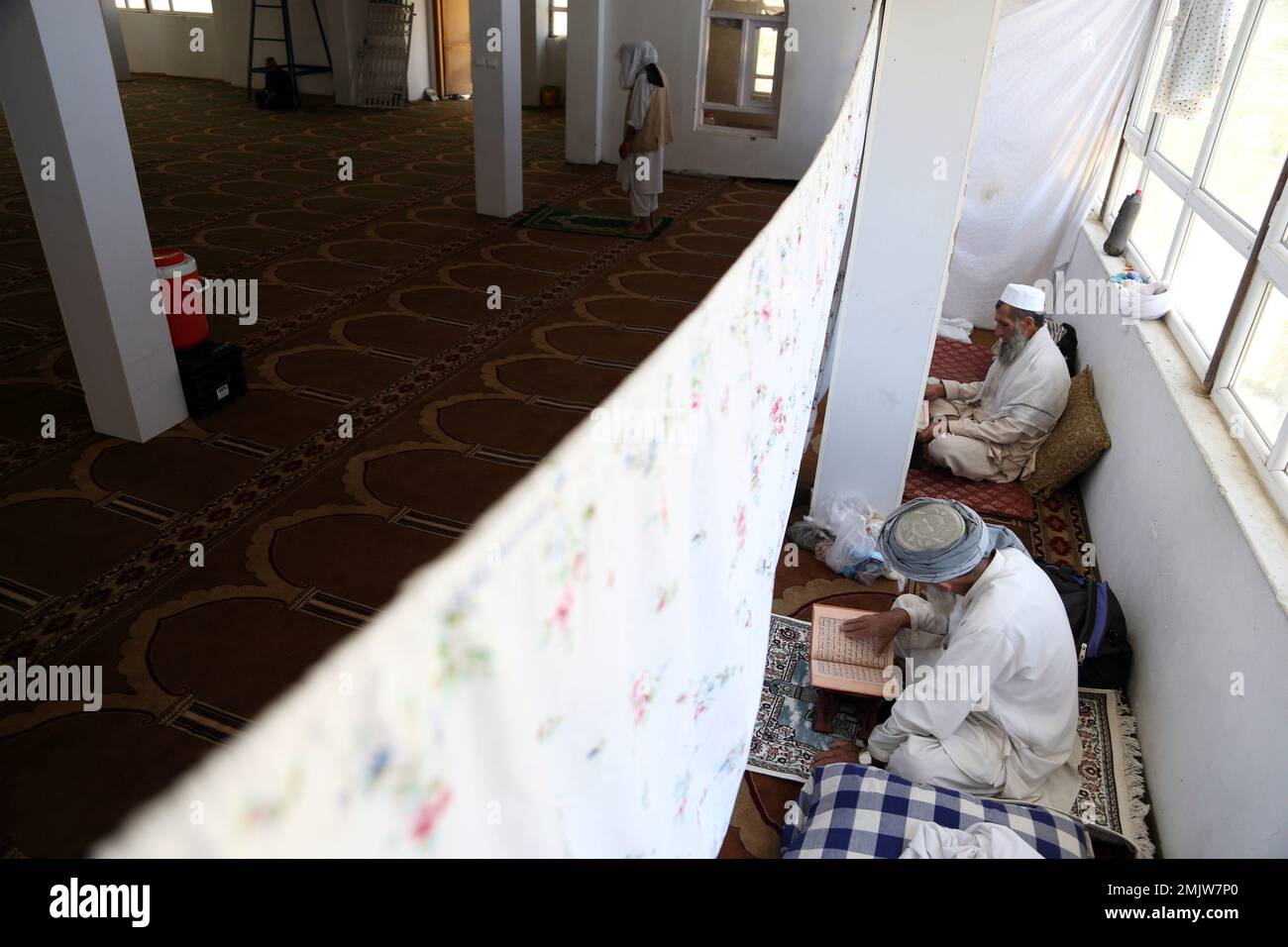 Muslim men, right, read verses of the Quran in a mosque during Itikaf ...
