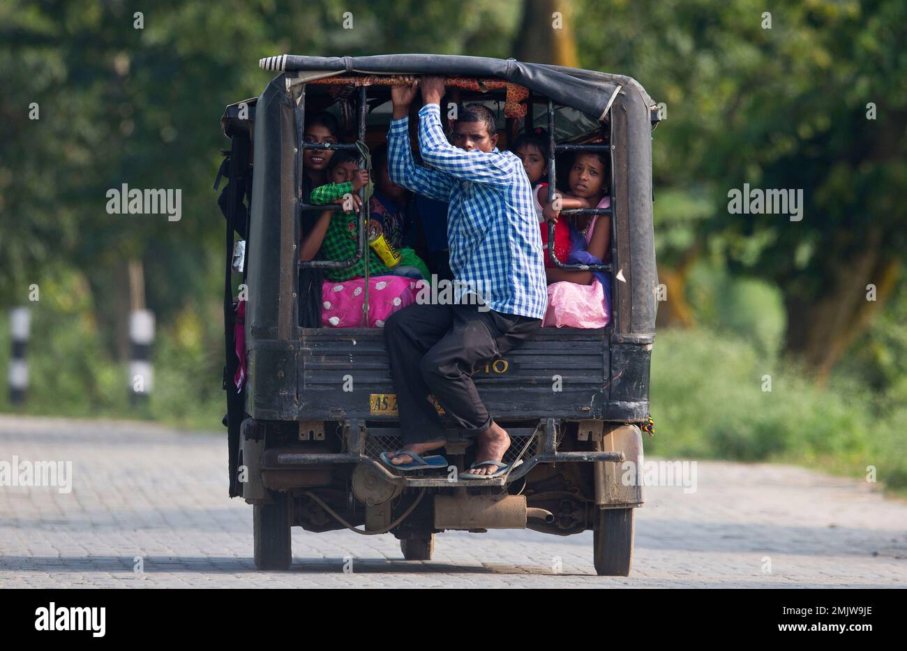 Indian passengers travel on an auto rickshaw on the outskirts of ...