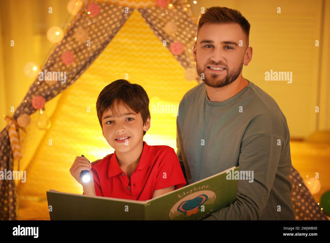Father and son with flashlight reading book at home Stock Photo - Alamy