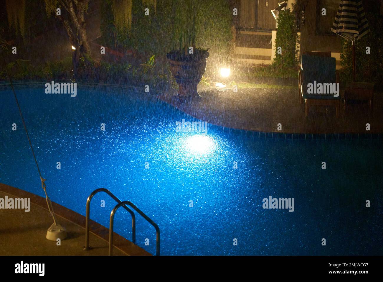A heavy tropical downpour in the courtyard of the condo at night floods ...