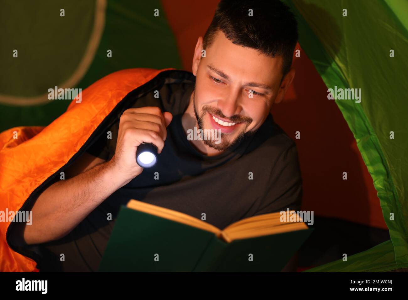 Man flashlight reading book hi-res stock photography and images - Alamy