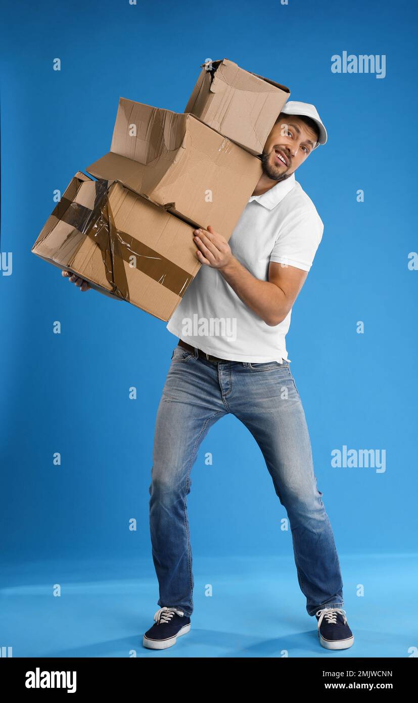 Emotional courier with damaged cardboard boxes on blue background. Poor ...
