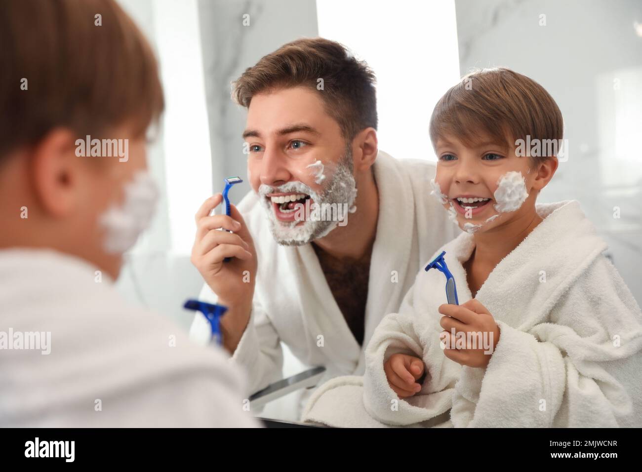 Dad shaving and son imitating him in bathroom Stock Photo - Alamy
