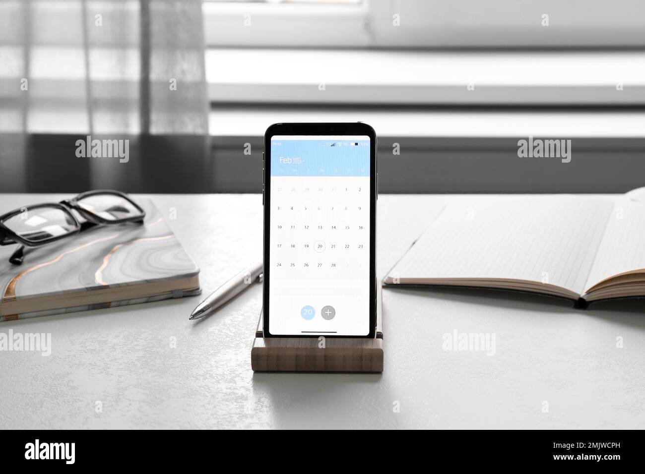 Modern smartphone with calendar on screen in office Stock Photo - Alamy