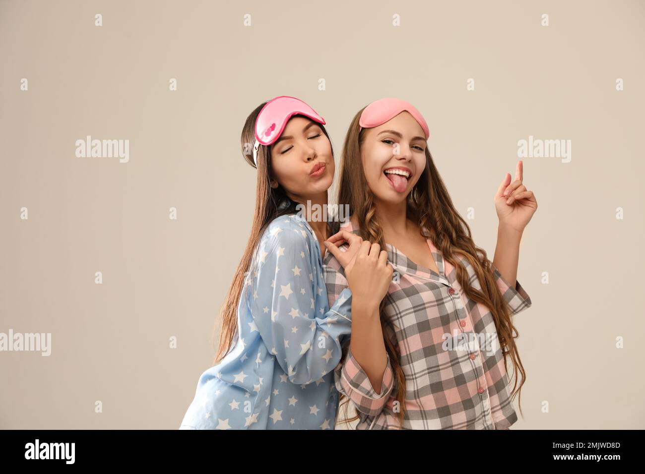 Beautiful women in pajamas on beige background. Bedtime Stock Photo - Alamy