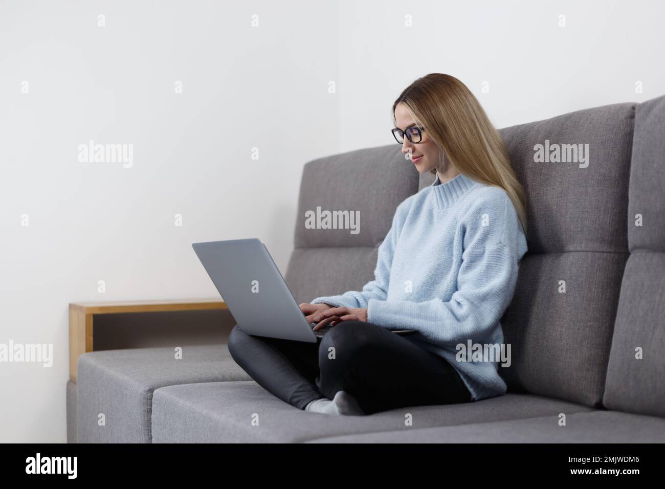 Female programmer typing code on laptop at home. Young woman coding on notebook computer while ...