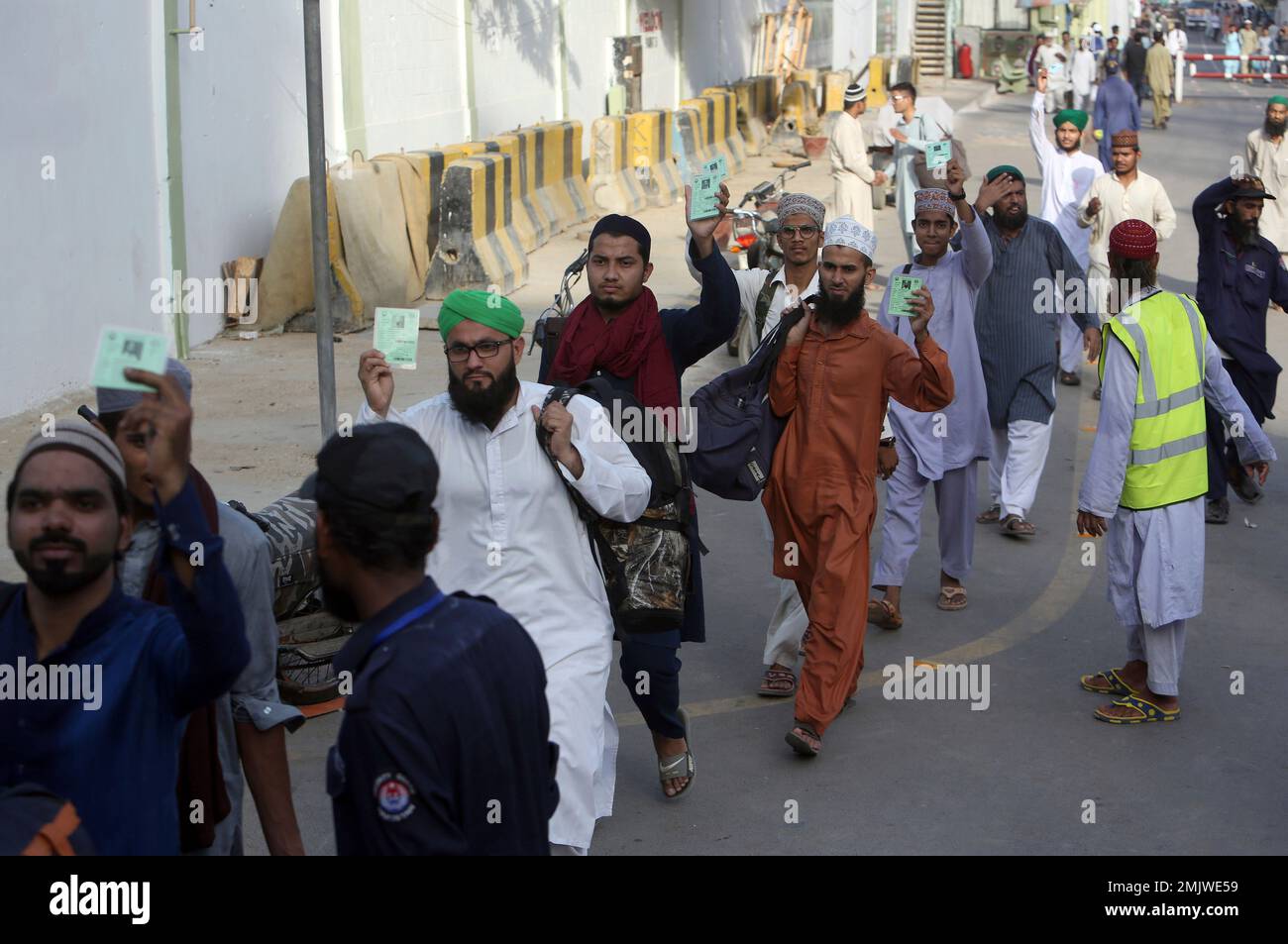 Muslim worshippers display their cards while arriving to observes ...