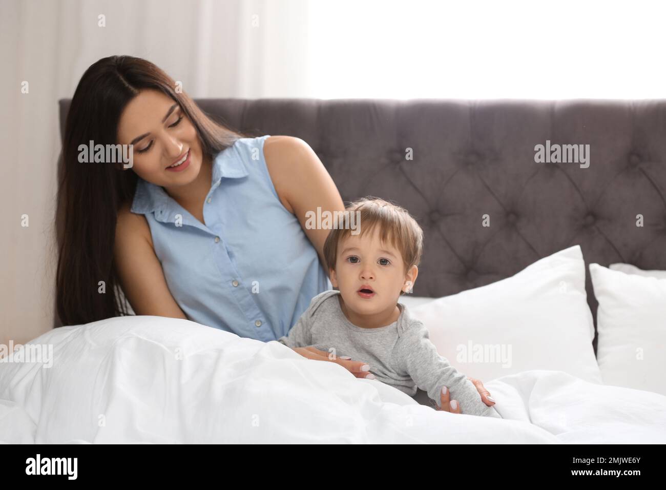 Young nanny with cute little baby in bedroom Stock Photo - Alamy