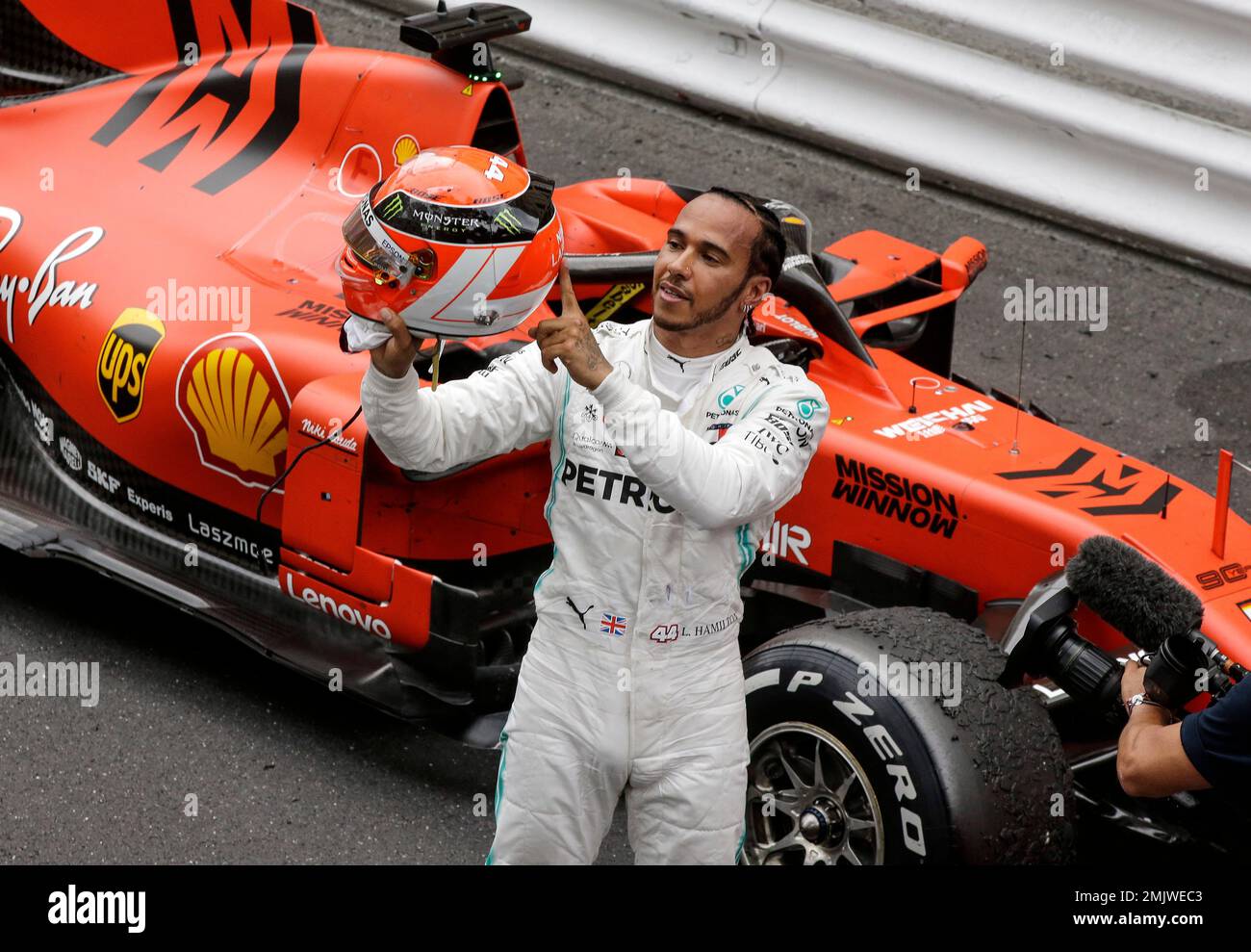 Mercedes driver Lewis Hamilton of Britain holds his red helmet to ...