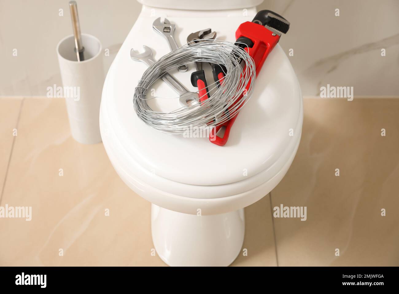 Plumber's tools on toilet bowl in bathroom Stock Photo - Alamy