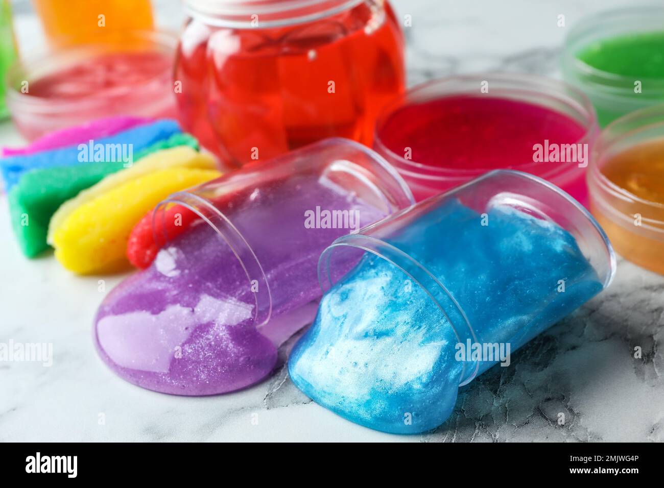 Different bright slimes on white marble background, closeup Stock Photo ...