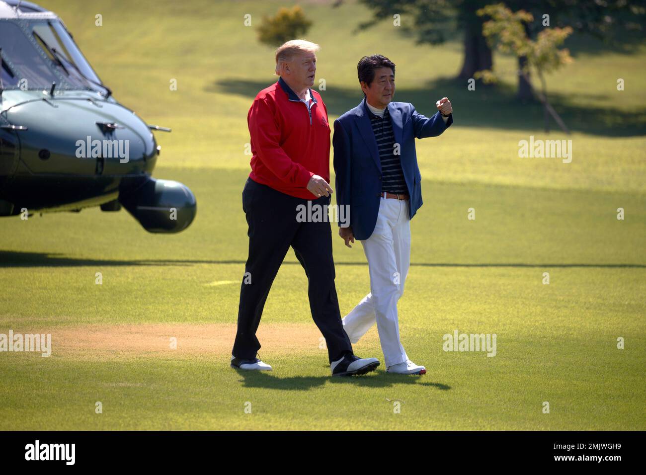 President Donald Trump walks with Japanese Prime Minister Shinzo Abe ...