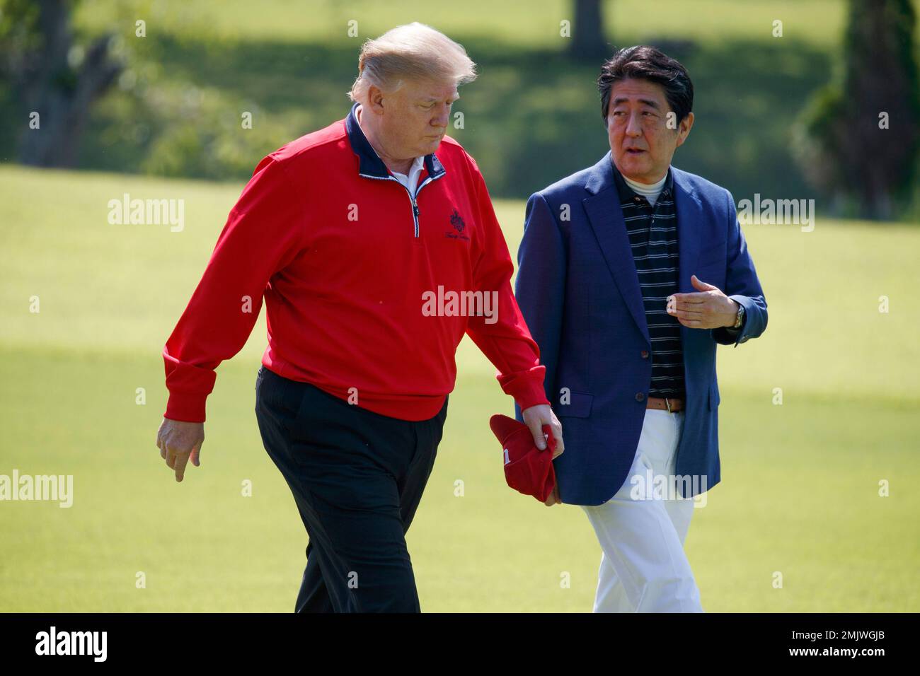 President Donald Trump walks with Japanese Prime Minister Shinzo Abe ...