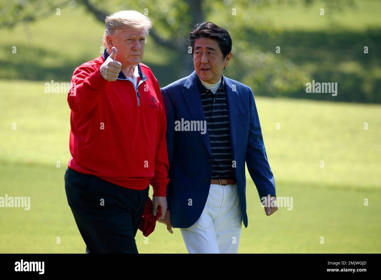 President Donald Trump walks with Japanese Prime Minister Shinzo Abe ...
