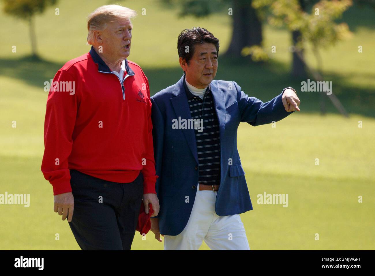 President Donald Trump walks with Japanese Prime Minister Shinzo Abe ...