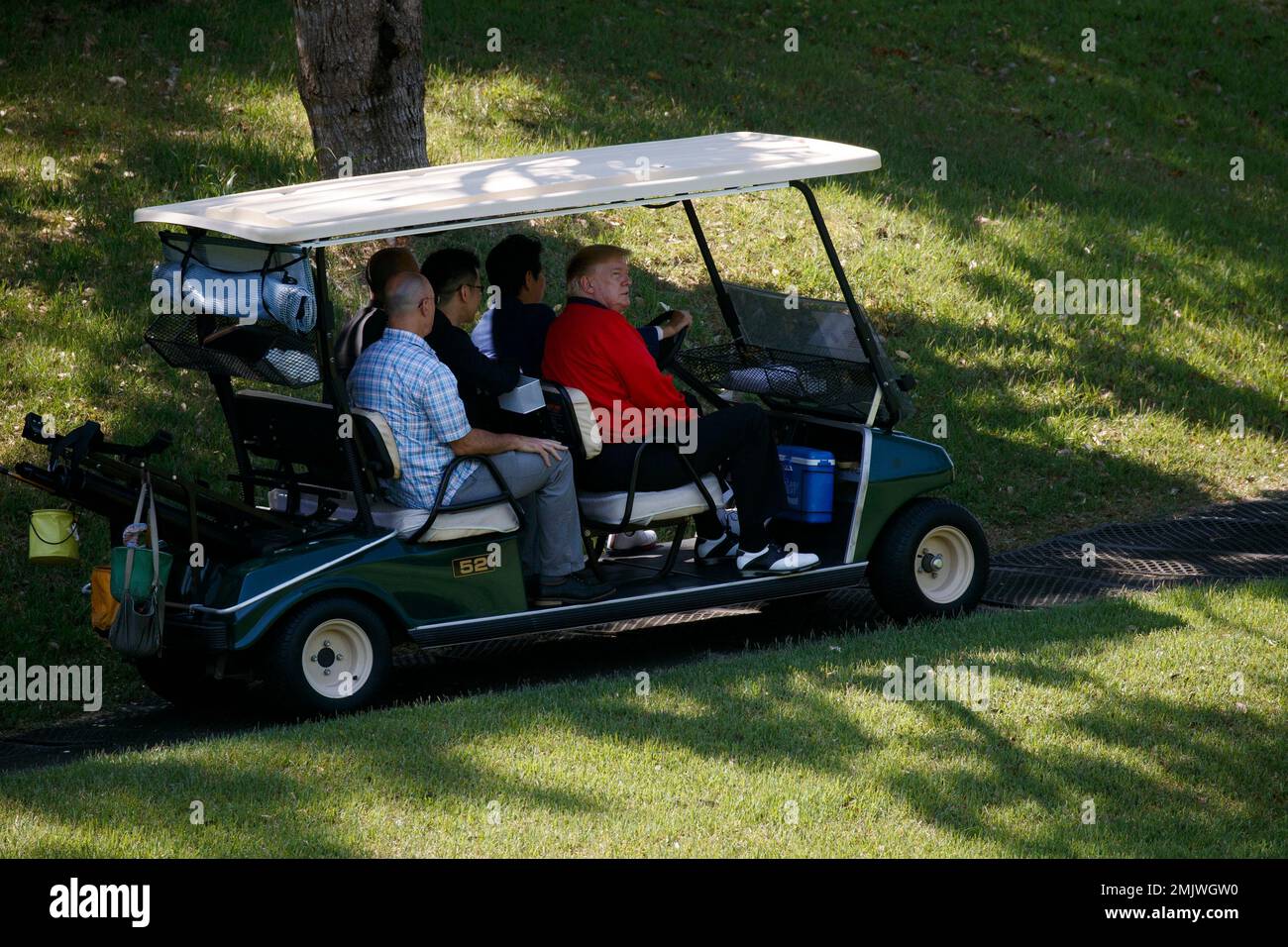 President Donald Trump rides in a golf cart with Japanese Prime ...