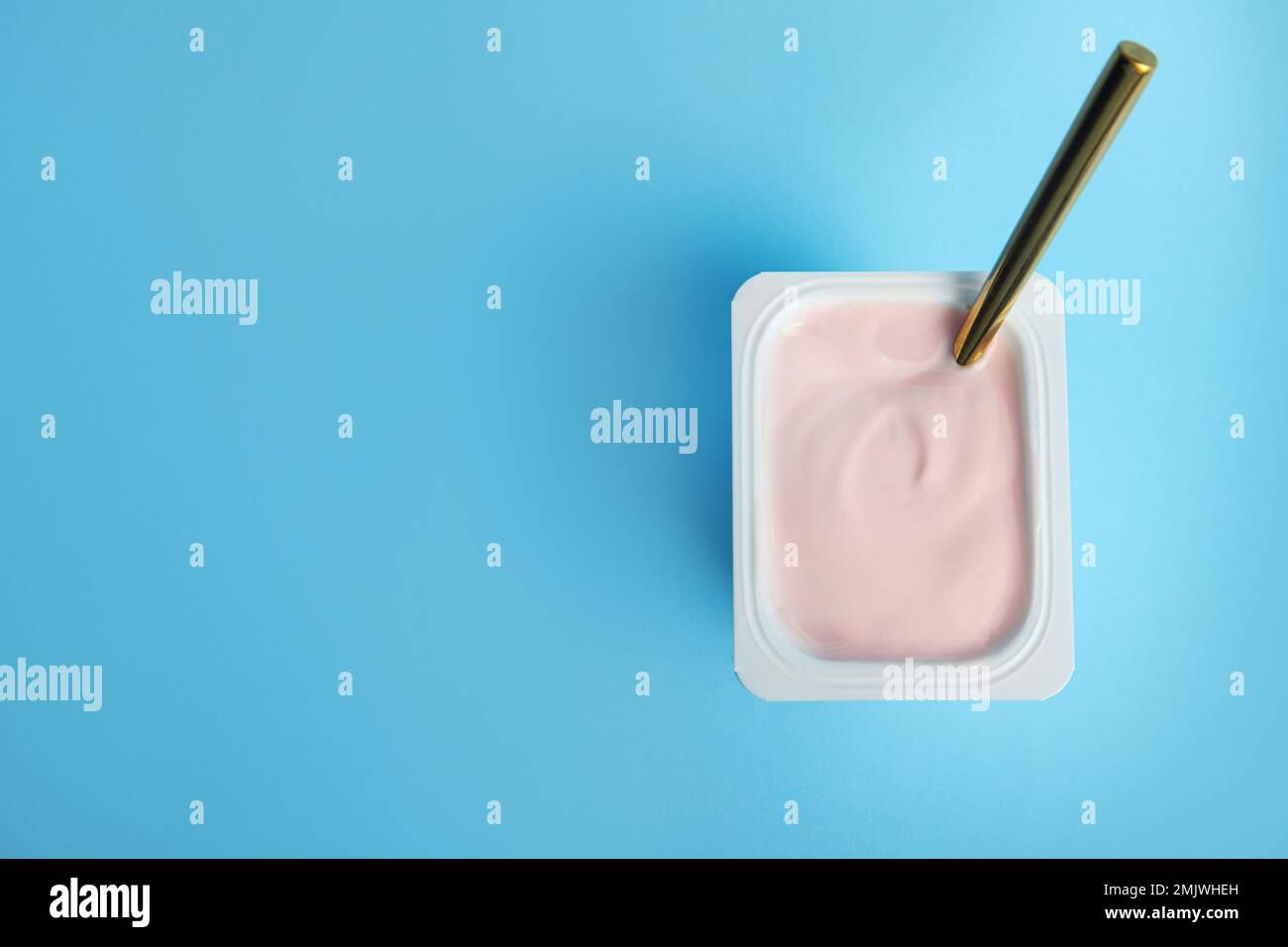 Tasty organic yogurt on light blue background, top view. Space for text ...
