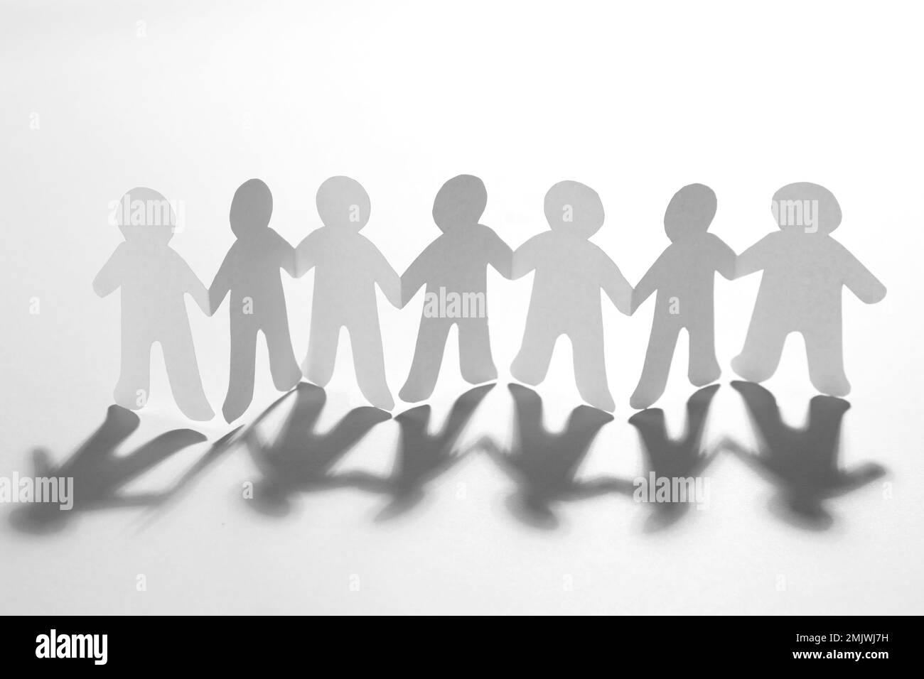 Paper people holding hands on white background. Unity concept Stock ...