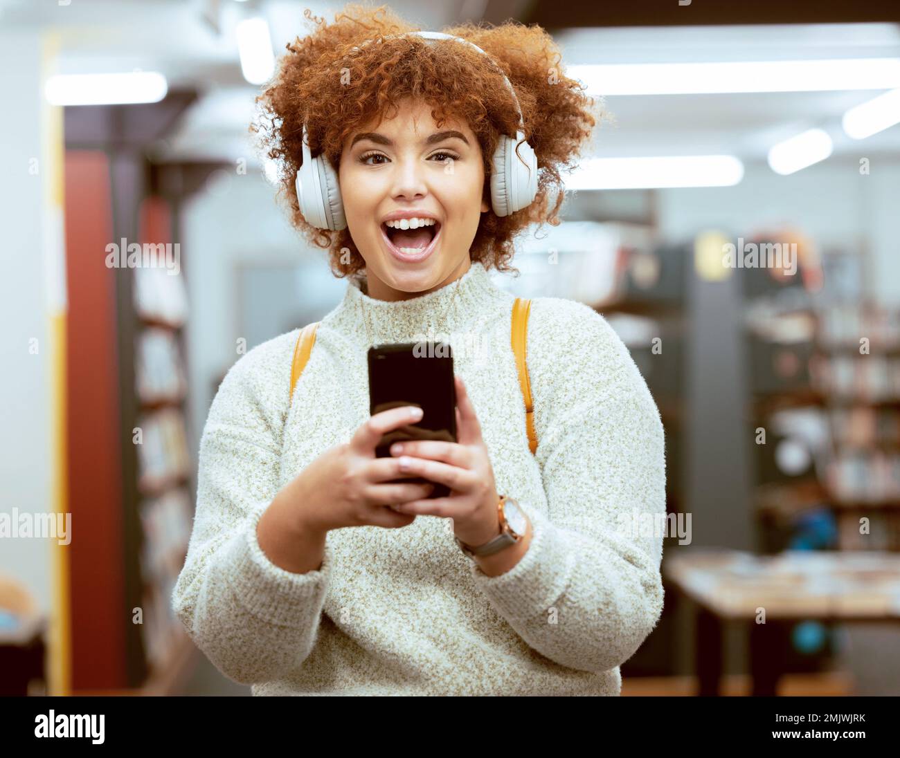 University student, woman and phone for texting, library and headphones ...