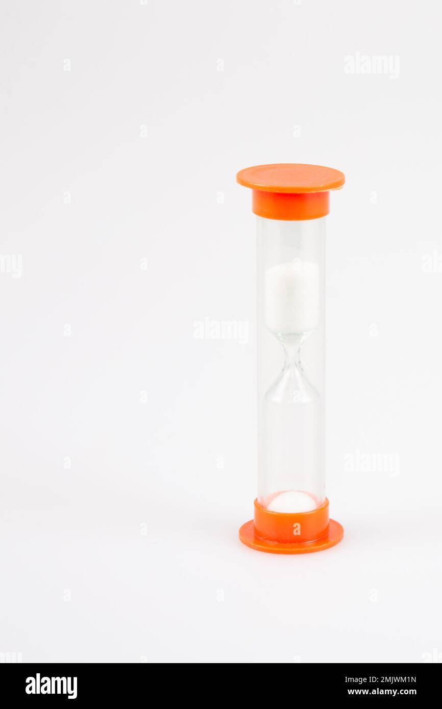 hourglass timer in plastic orange in grey background with white sand ...