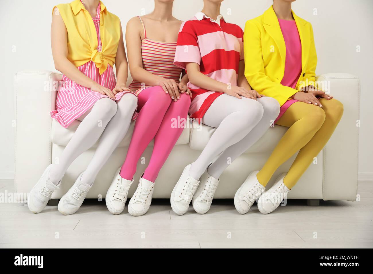 Women wearing colorful tights sitting on sofa indoors, closeup Stock ...