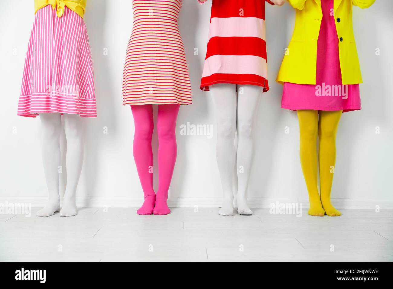 Women wearing colorful tights near white wall, closeup Stock Photo - Alamy