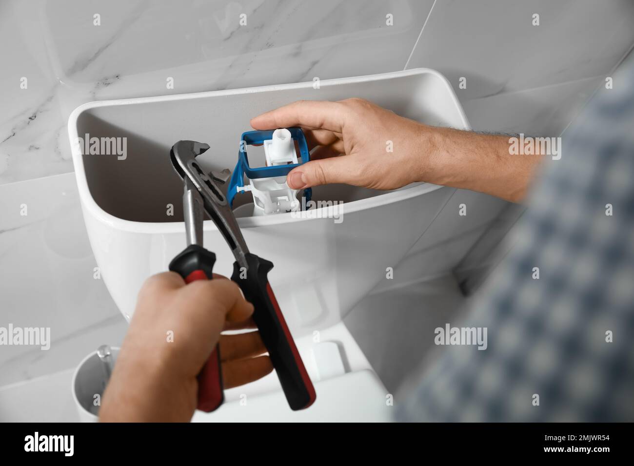 Professional plumber repairing toilet in bathroom, closeup Stock Photo ...