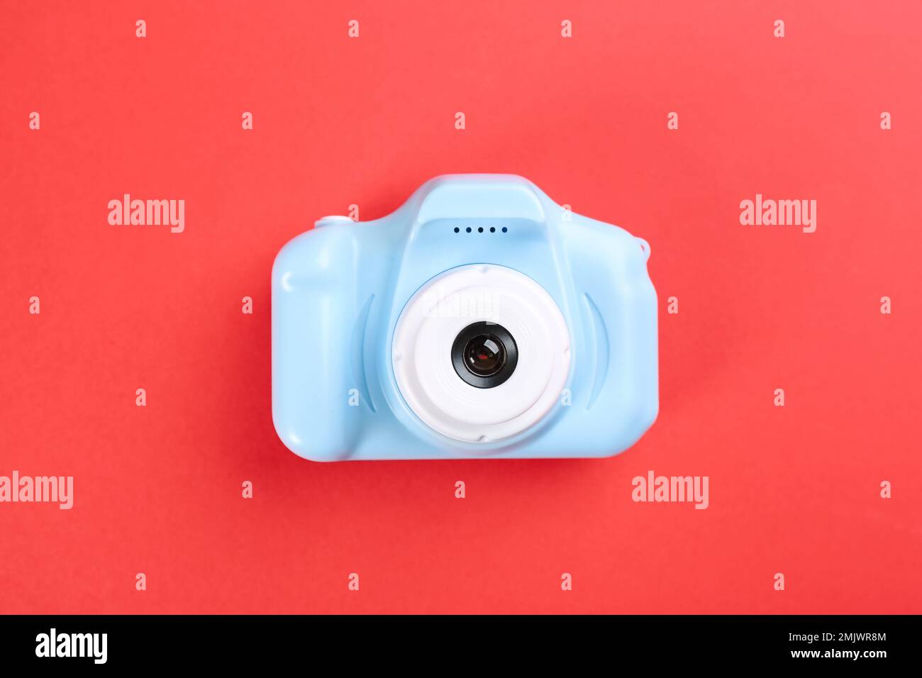 Light blue toy camera on red background, top view Stock Photo - Alamy