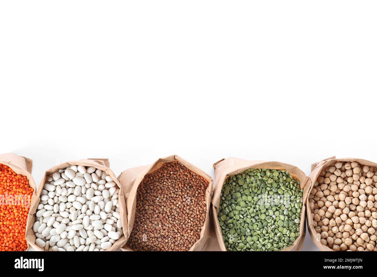 Different types of legumes and cereals in paper bags on white ...