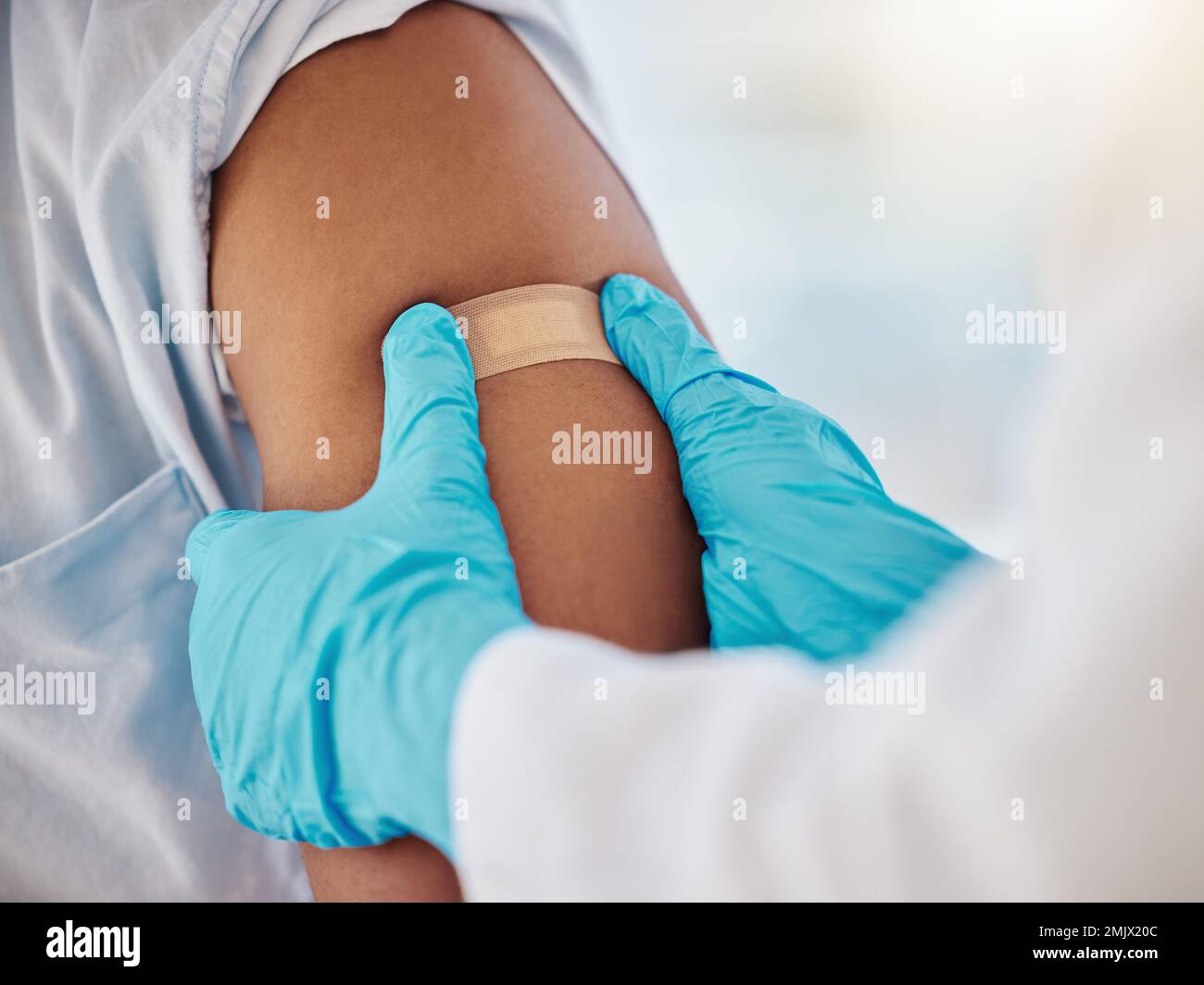 Covid, vaccine and plaster on the arm of a black man patient in a ...