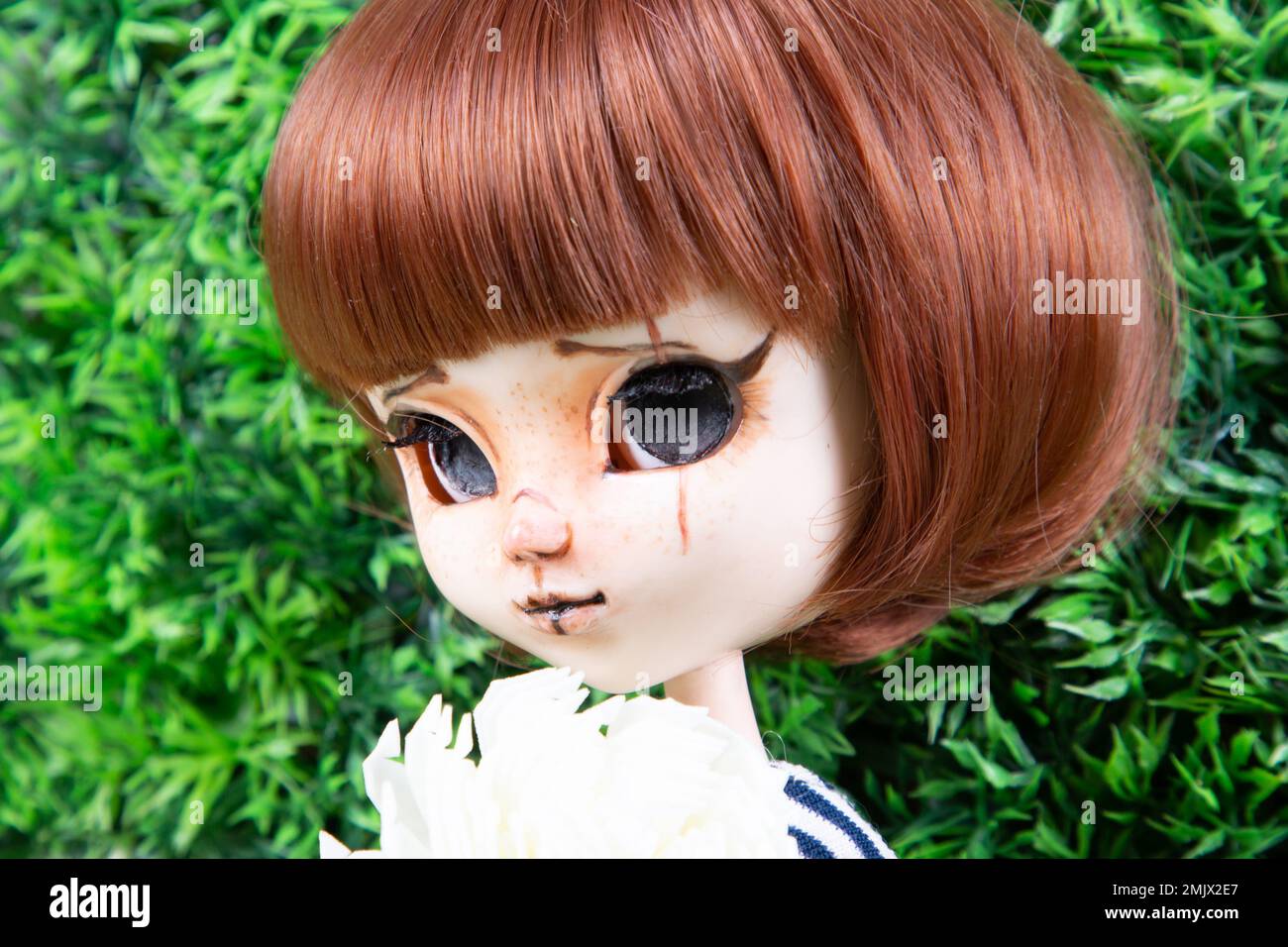 doll scary plastic face portrait in green background Stock Photo - Alamy