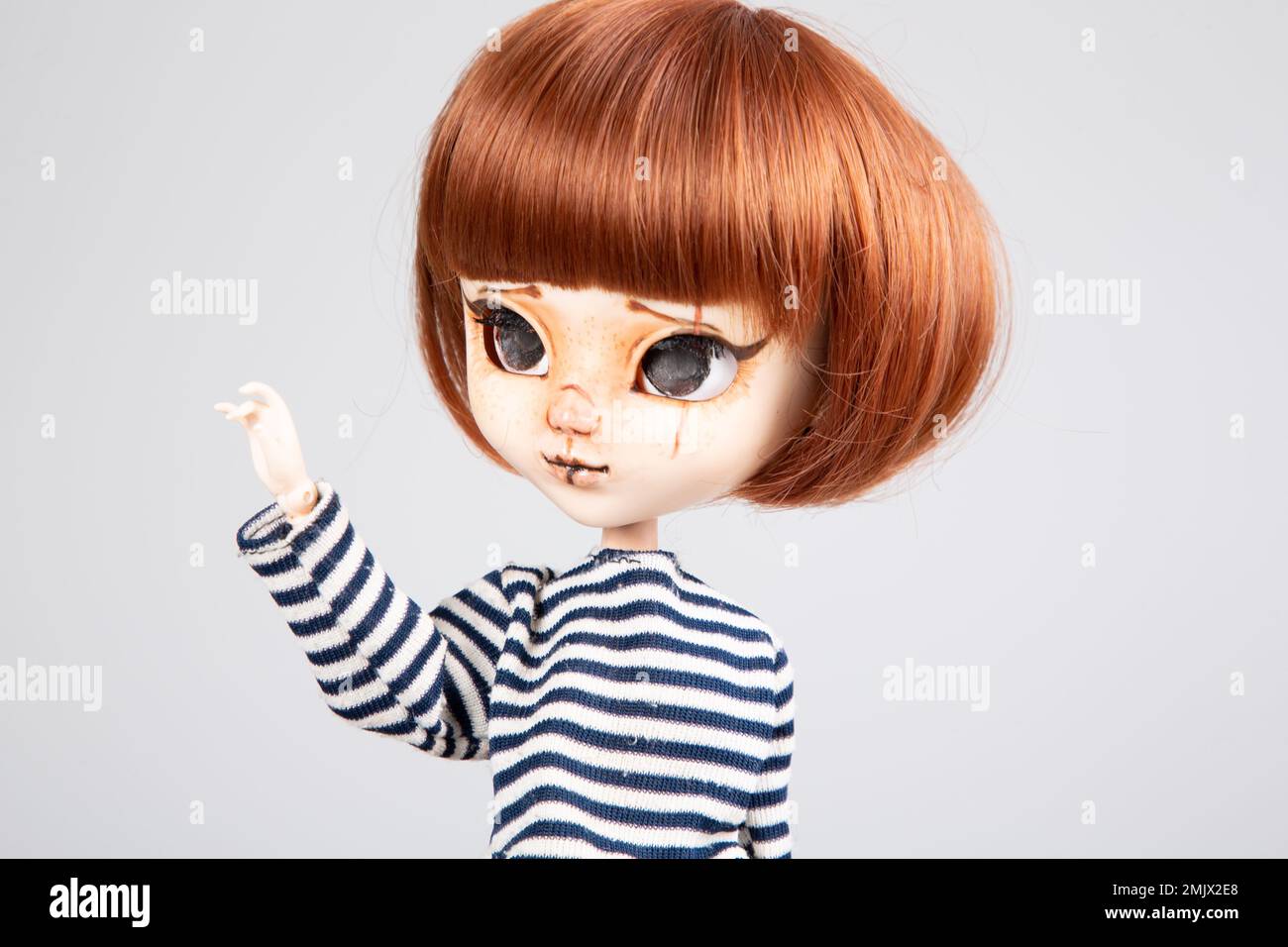 pretty doll red hairs hands up in white background Stock Photo - Alamy