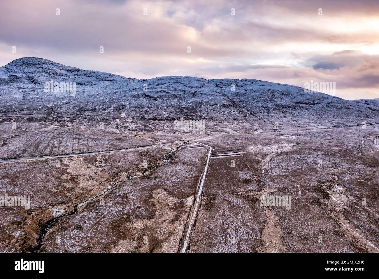 The R251 next to the snow covered Mount Errigal, the highest mountain ...