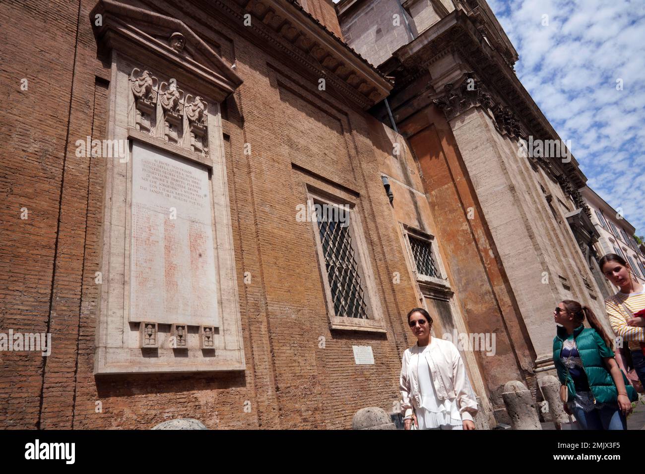 People walk past a plaque commemorating the fallen soldiers of WWI ...