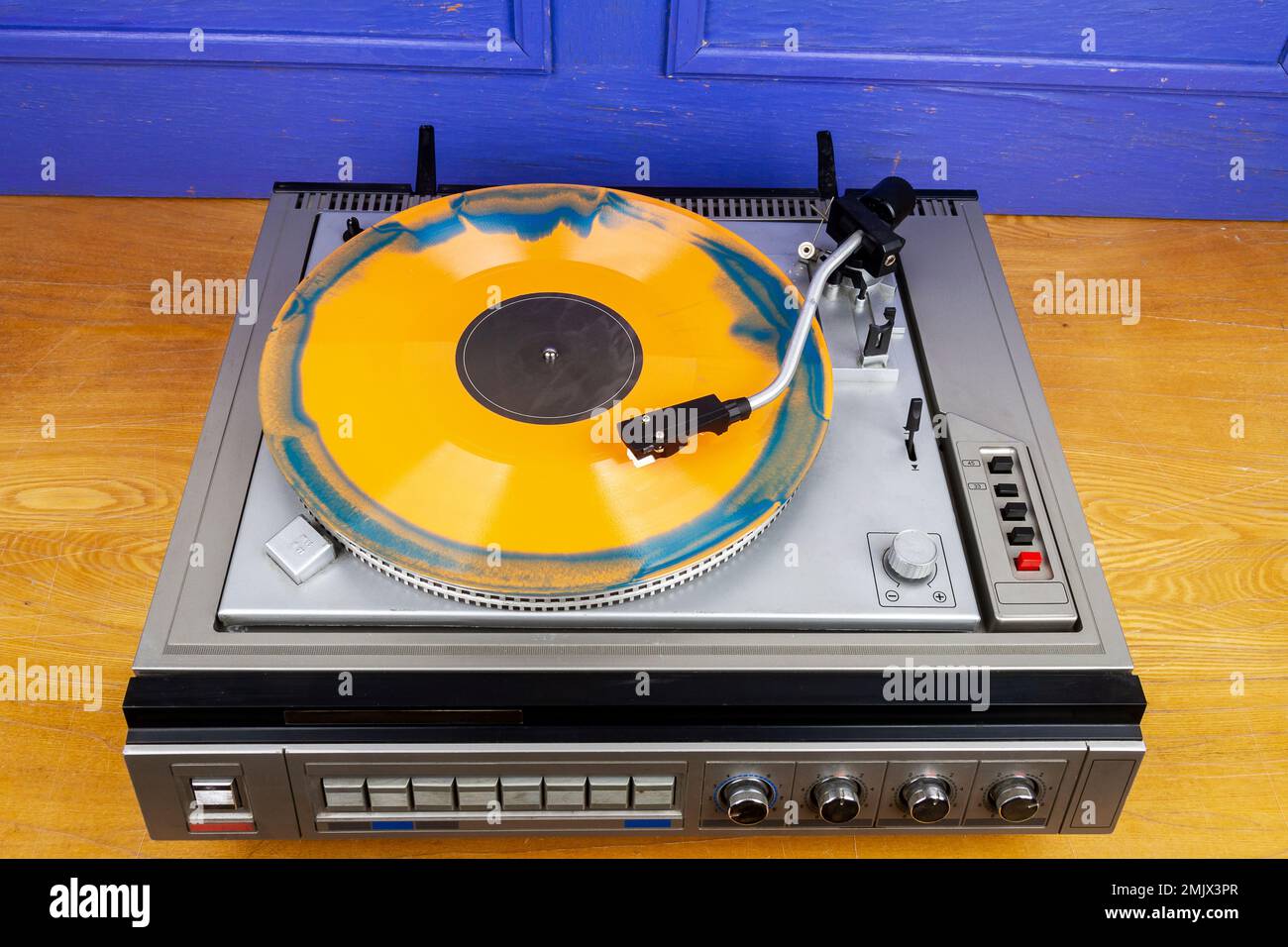 Vintage turntable vinyl record player with blue and orange vinyl on a ...