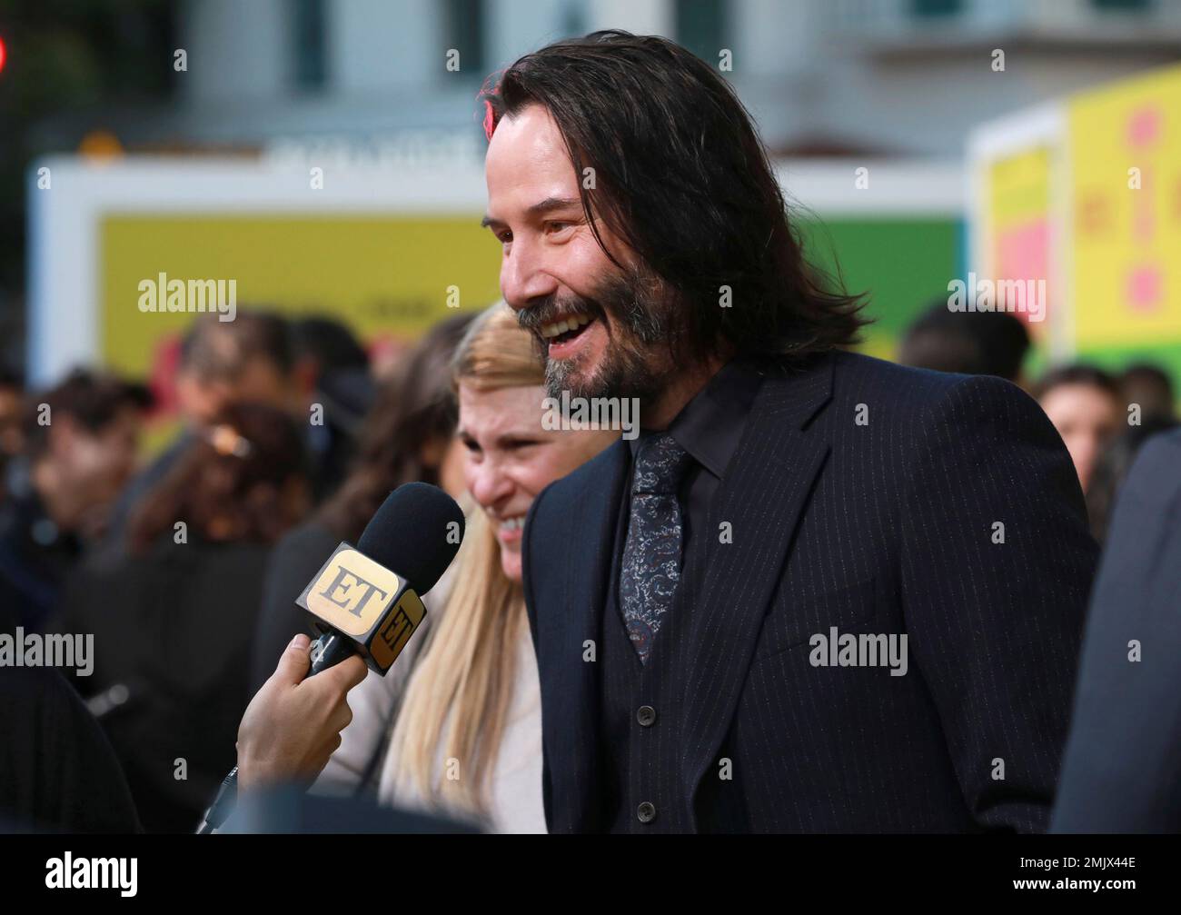 Keanu Reeves speaks with journalists as he arrives at the premiere of ...