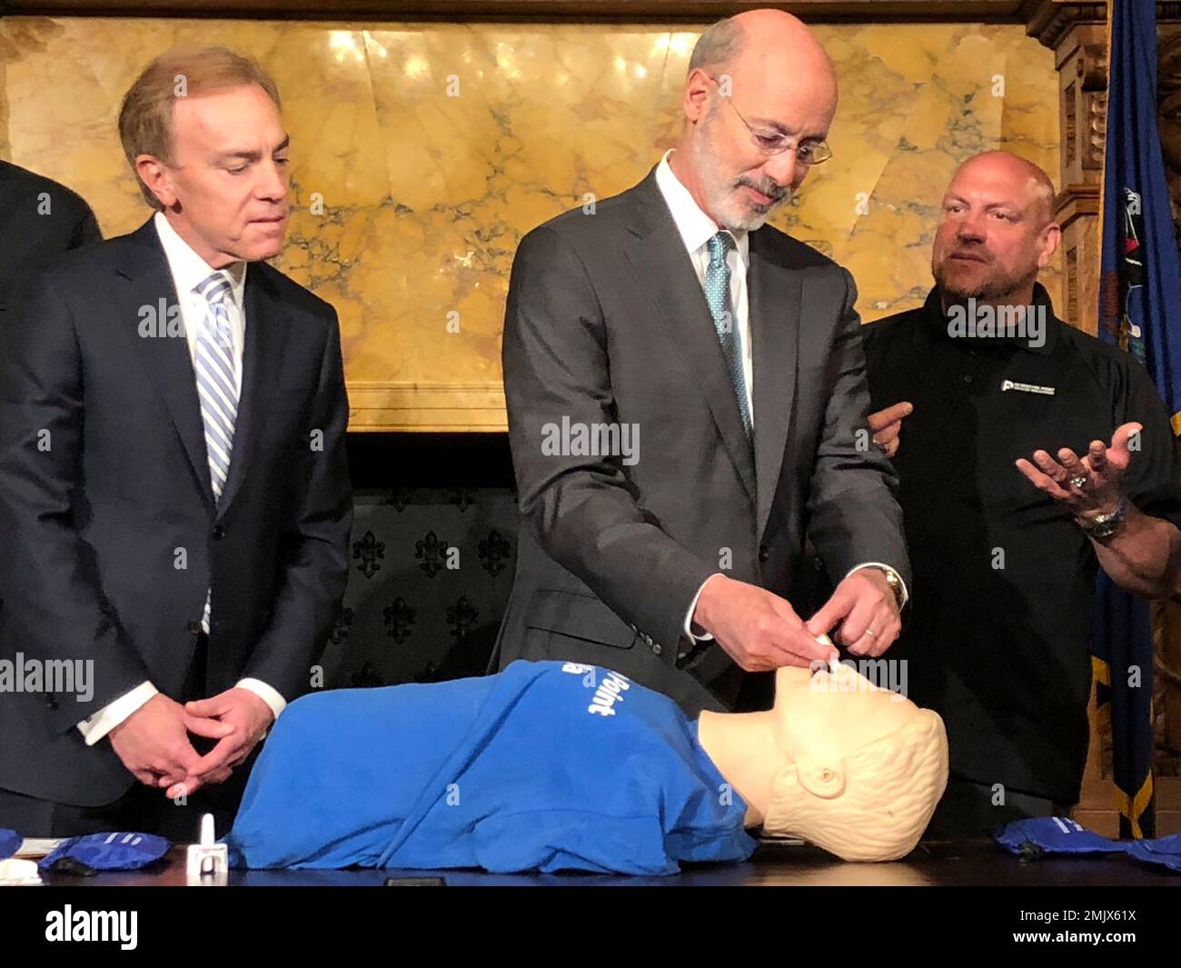 Gov. Tom Wolf, center, listens to trainer Elvis Rosado, right, of ...