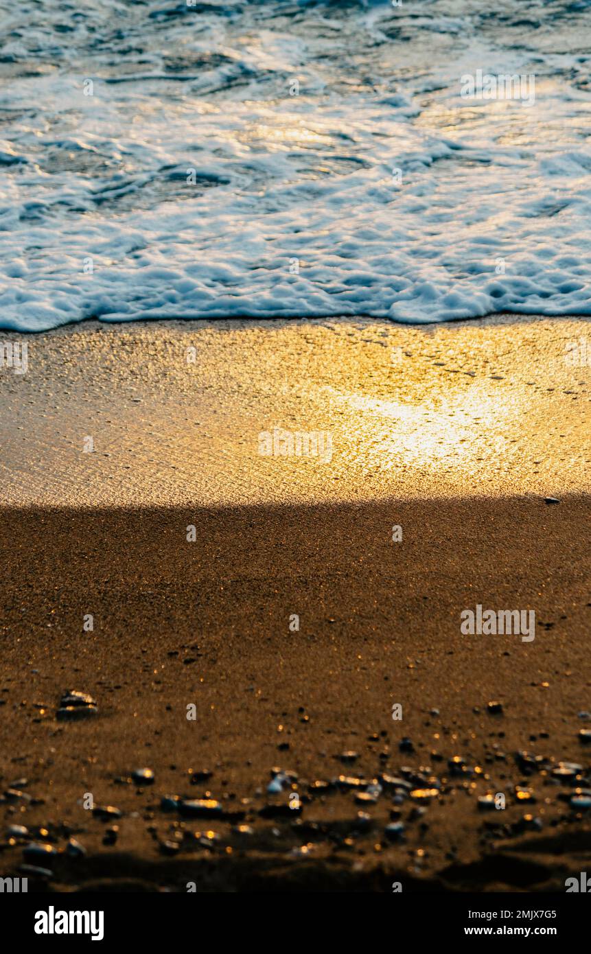 Three layered texture on beach: sand, water and sunlight reflection ...