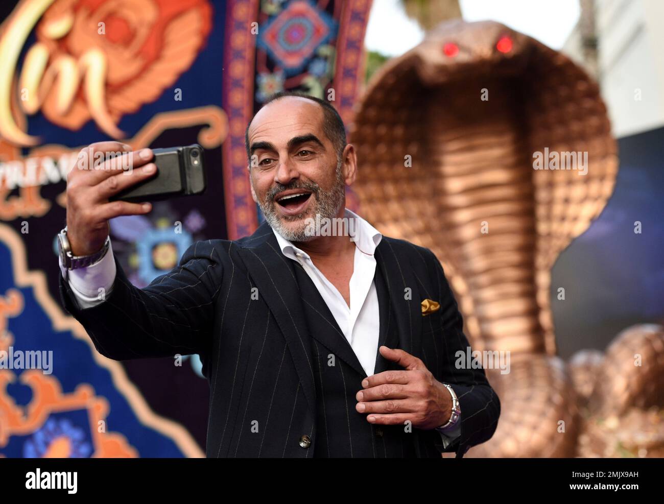 Navid Negahban, a cast member in "Aladdin," takes a selfie at the ...