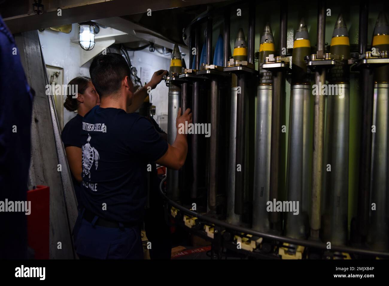 U.S. Coast Guard Seaman Santiago Jauregui loads 76mm rounds into the MK ...