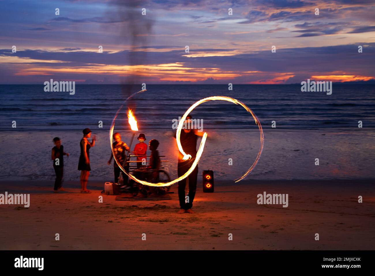 street performers put on a fire show for tourists on the beach after ...