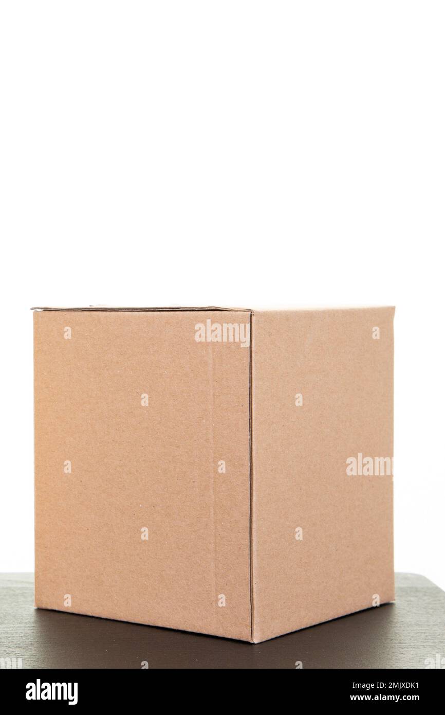 One cardboard box brown in white background black table Stock Photo - Alamy