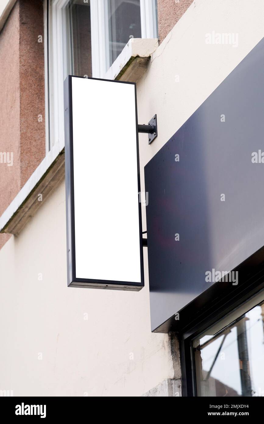 vertical white signage on shop front street Stock Photo - Alamy